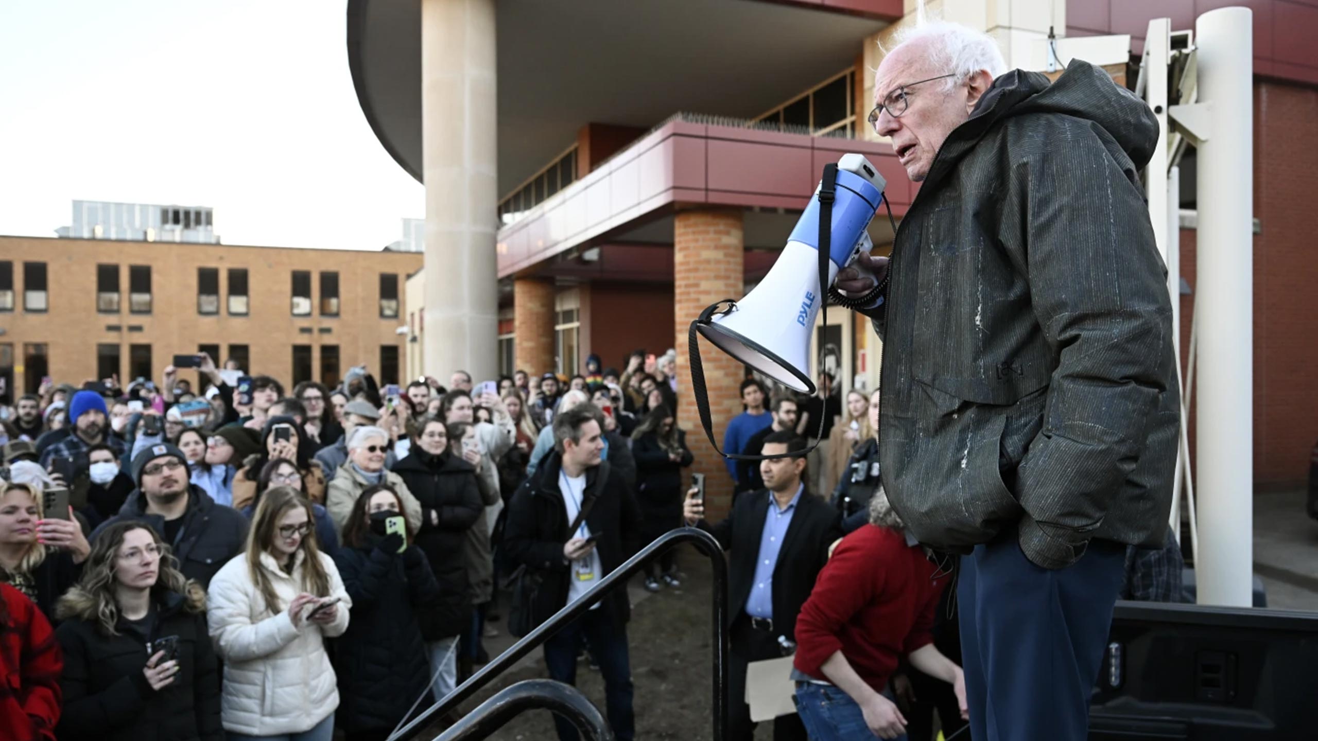 Bernie Sanders is standing alone on the back of a pickup truck